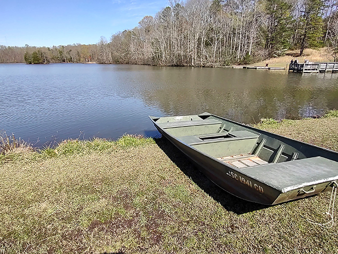 A humble fishing boat waits patiently by Lake Crawford's shore &ndash; no fancy yacht required for the simple pleasure of drifting among rippling reflections.