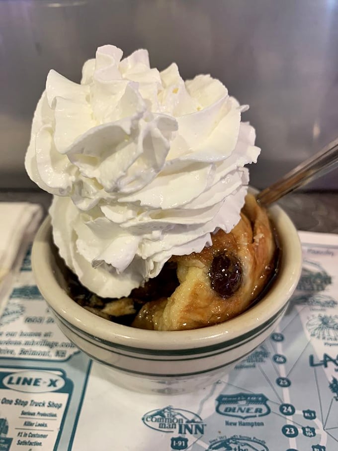Bread pudding that whispers sweet nothings to your taste buds, topped with a cloud of whipped cream that's showing off its perfect peaks.