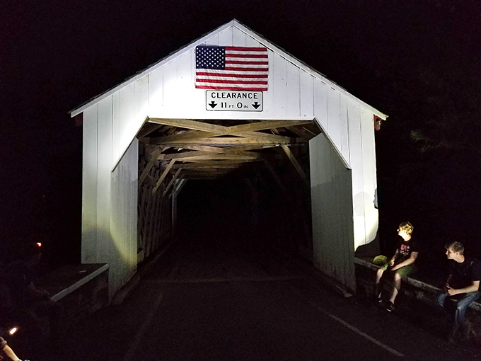 Morning light captures the bridge in its natural habitat&mdash;nestled among trees with a historic stone house standing sentinel nearby.