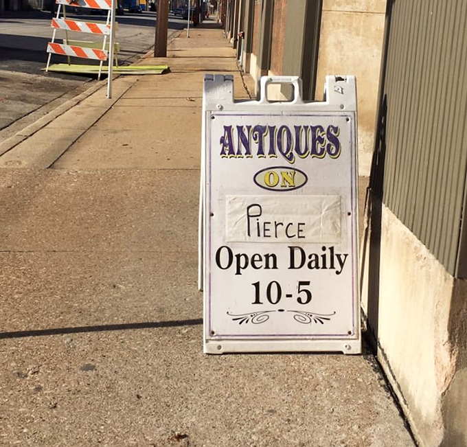 The sidewalk sentinel announces daily hours. This unassuming sign has guided countless treasure hunters to antique nirvana.