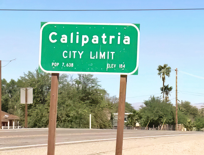 The city limit sign tells a story in numbers: population 7,638, elevation -184 feet&mdash;a community literally living below sea level but certainly not beneath notice.
