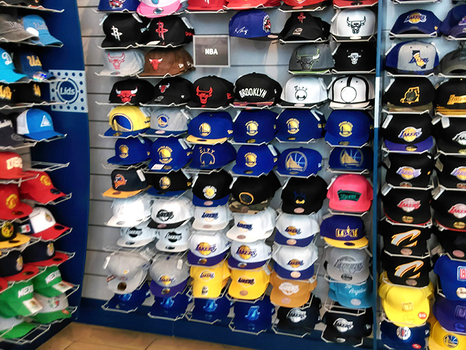 A wall of sports caps displays team loyalties like a colorful census of California's divided sports allegiances&mdash;choose your tribe carefully.