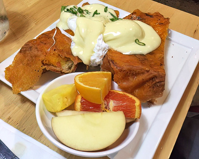 Benedict perfection: poached eggs perched atop crispy bread, draped in hollandaise with citrus brightness cutting through the richness. Breakfast engineering at its finest.