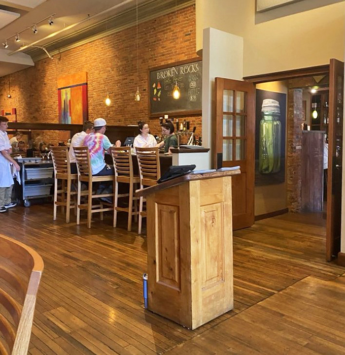 The bar area invites lingering conversations and "just one more" moments under those playful green pendant lights.
