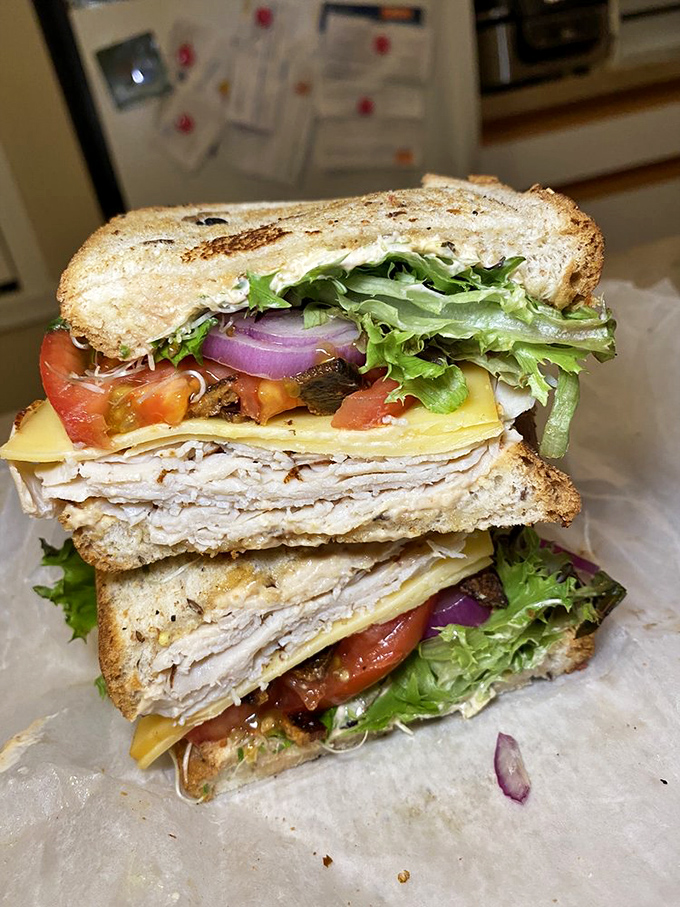 The club sandwich, stacked higher than some downtown Columbus buildings, requires a strategic approach and possibly an engineering degree to eat.