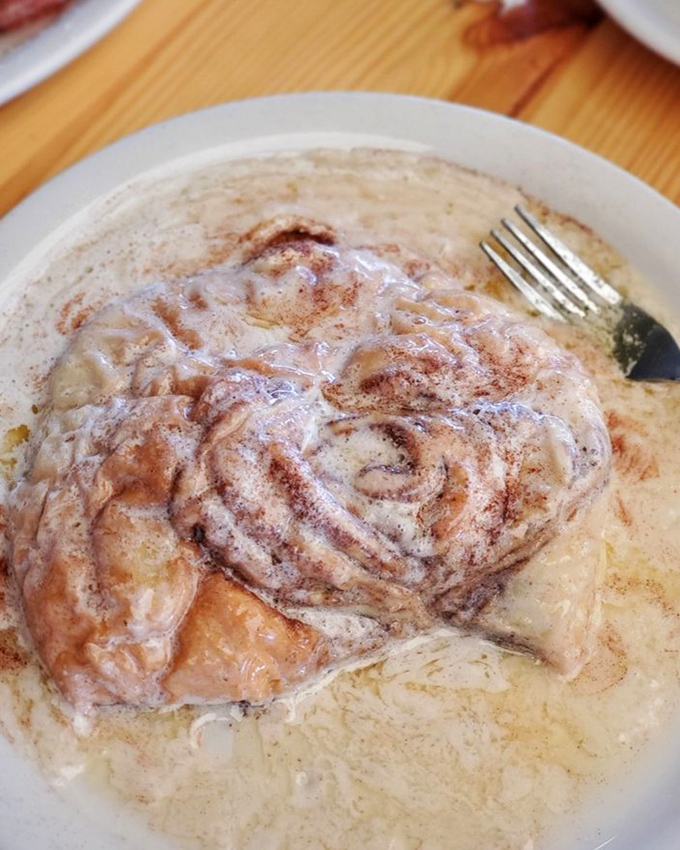 This cinnamon roll isn't just a pastry, it's an event—swimming in sweet glaze and demanding to be the center of attention.