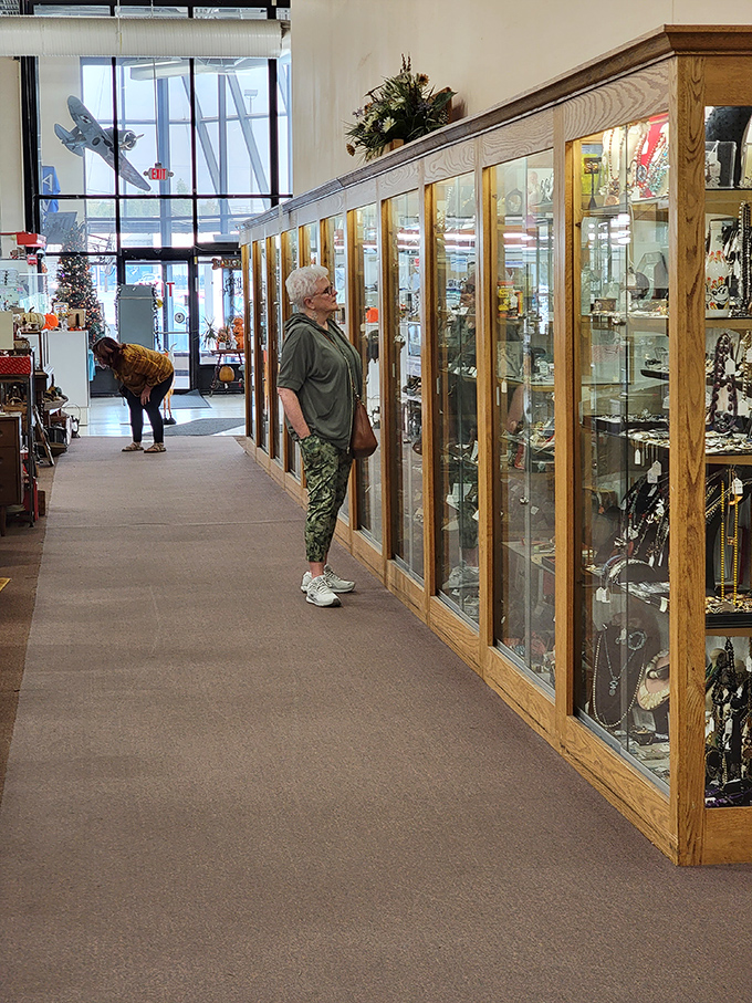 Shoppers lost in contemplation of treasures behind glass. The universal pose of the antique hunter: part detective, part dreamer, all determination.