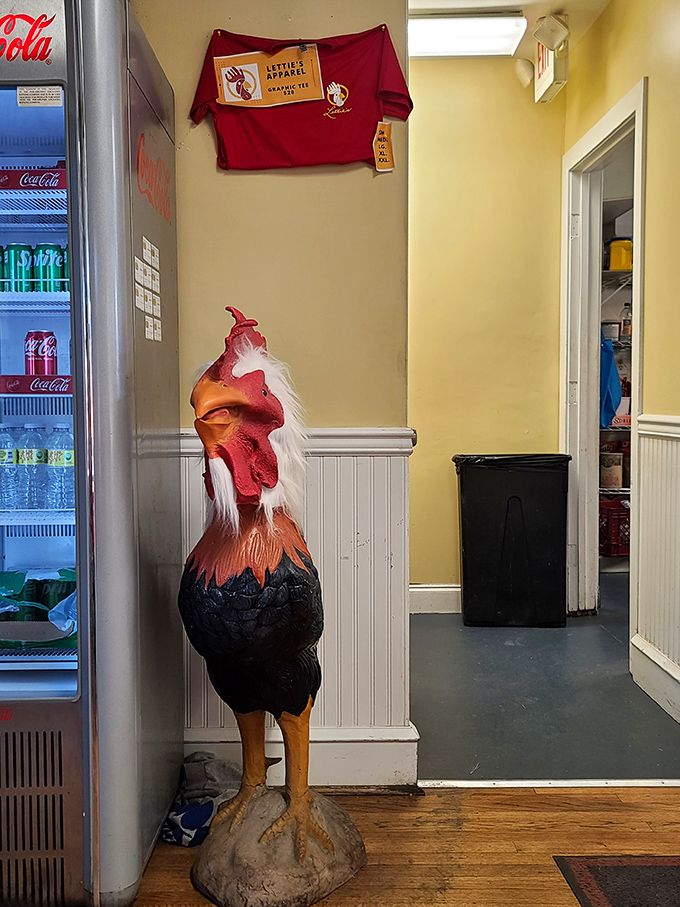 The guardian rooster stands watch, silently judging those who might consider leaving without trying the fried chicken. His expression says it all.