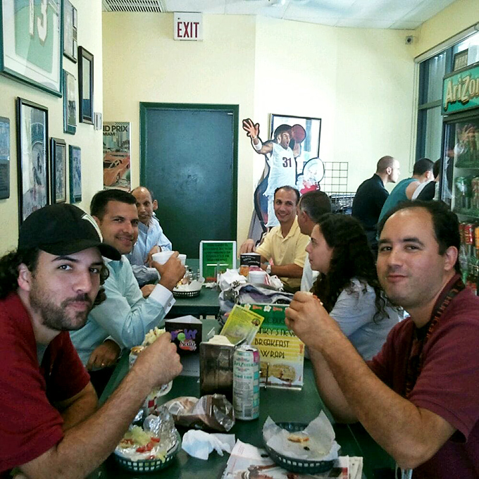 Happy diners share stories and sandwiches, creating the kind of community atmosphere that makes meals memorable.