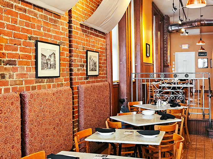 Cozy banquettes against exposed brick walls create dining nooks that feel both intimate and communal. The perfect backdrop for memorable meals.