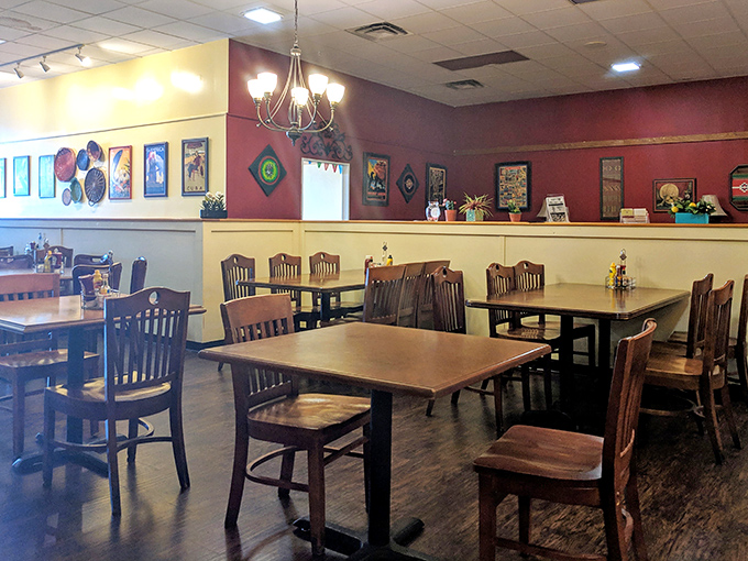 Tables arranged with care under soft lighting and burgundy walls create an atmosphere where breakfast conversations naturally extend into lunchtime.