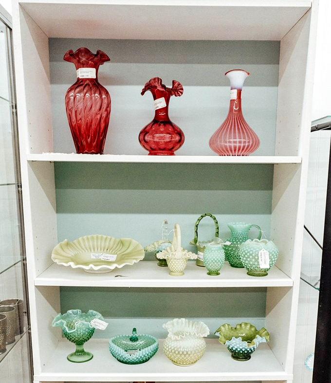 Mint green and ruby red glassware arranged with museum-like precision showcases the delicate artistry of Fenton and other collectible glass that grandmothers everywhere coveted.