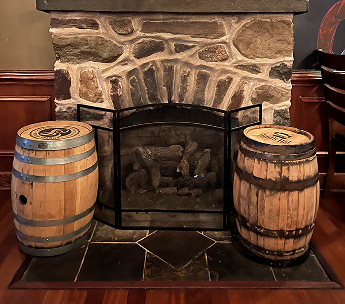 The stone fireplace flanked by whiskey barrels creates a cozy focal point that practically demands you linger over dessert and coffee.