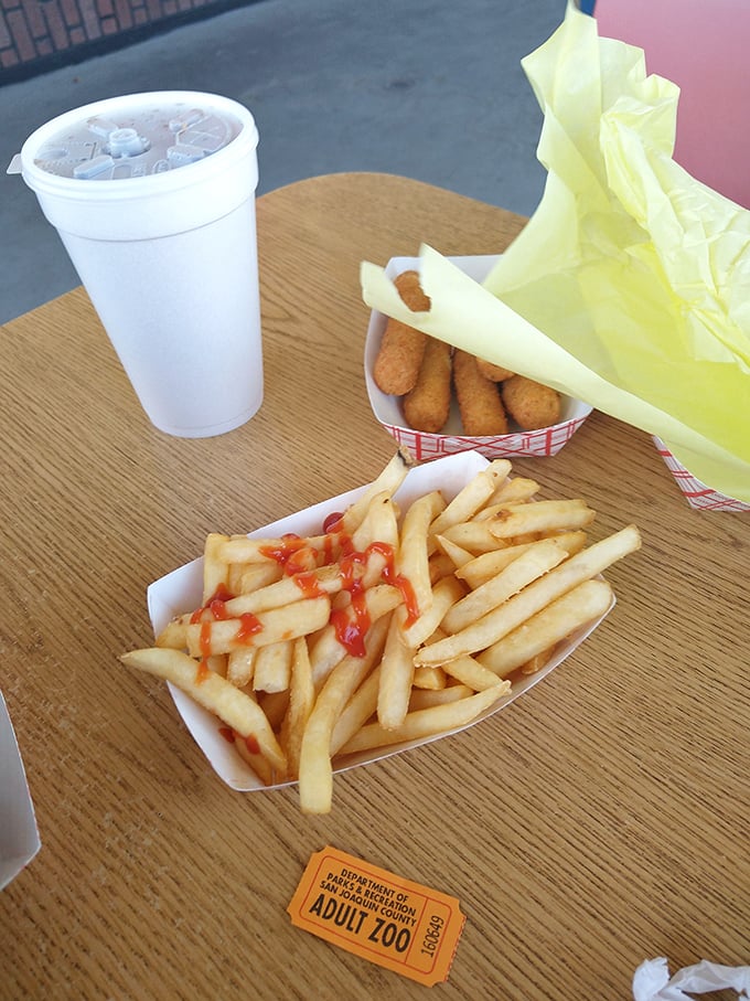 The holy trinity of drive-in dining: crispy fries, cold drink, and the anticipation of what's still wrapped in that yellow paper.