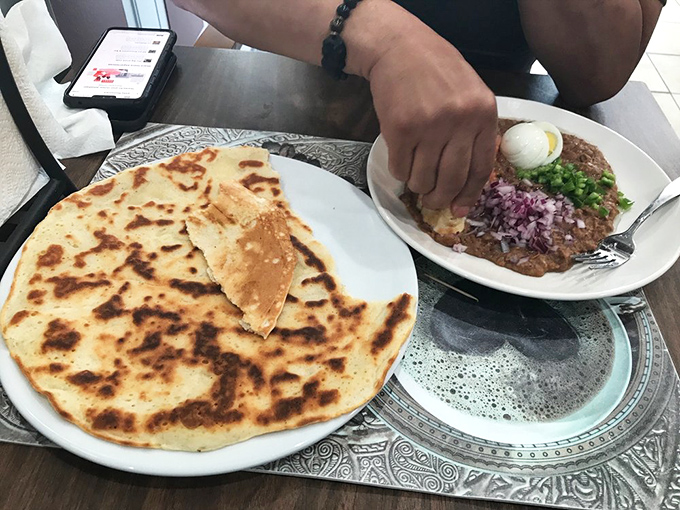 Traditional ful medames with pita offers a breakfast revelation—creamy fava beans elevated by fresh toppings and the joy of tear-and-dip dining.