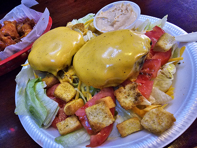 Two perfectly cooked patties smothered in cheese atop a garden of fresh veggies. Like a burger wearing its Sunday best. 