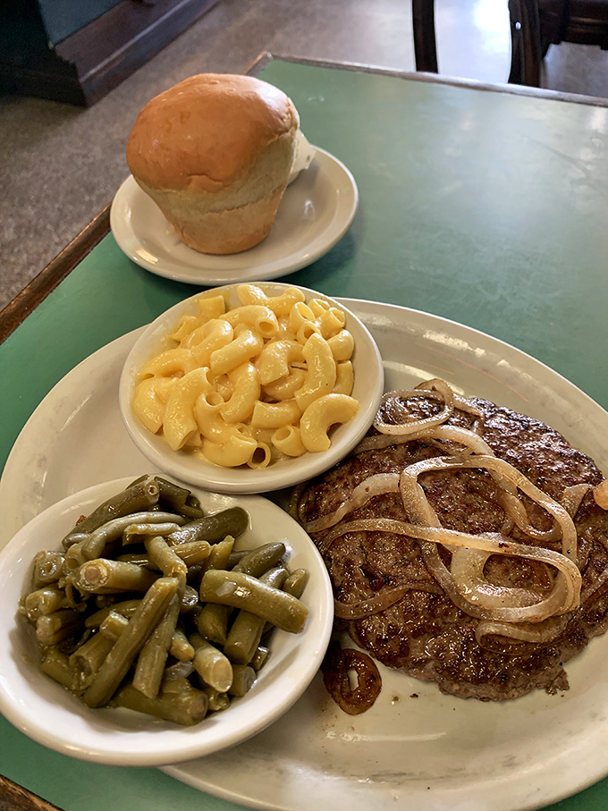 The hamburger steak with grilled onions, green beans, and mac and cheese&mdash;a plate that says "You won't need dinner tonight." That roll is just showing off.