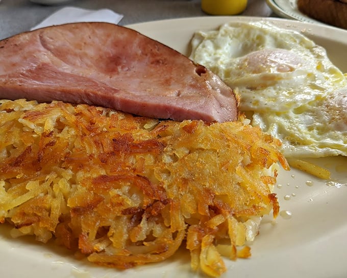 The holy grail of breakfast: hash browns with that perfect crisp-to-tender ratio, ham cut thick, and eggs cooked just right. Morning glory on a plate.