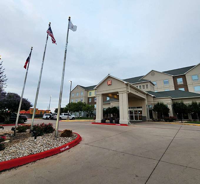 This welcoming hotel entrance, complete with Texas and American flags, offers weary travelers a comfortable home base for Abilene adventures.