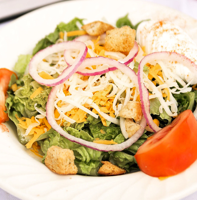 A house salad that doesn't apologize for being healthy&mdash;bright, crisp, and colorful with just enough cheese to remind you that pleasure matters too.