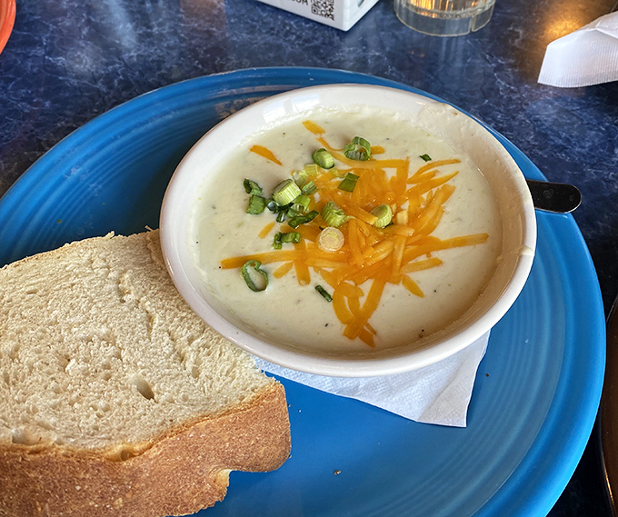A bowl of creamy soup topped with sharp cheddar and green onions&mdash;comfort food that's gotten a college education and come home sophisticated.