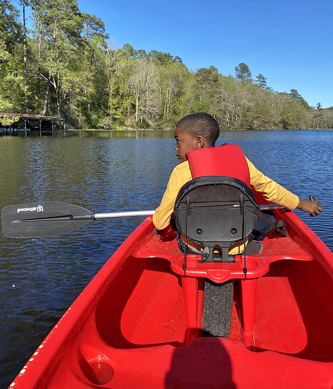 A young explorer navigates Lake Tilley's calm waters. That red canoe might as well be the Starship Enterprise for the adventure it provides.
