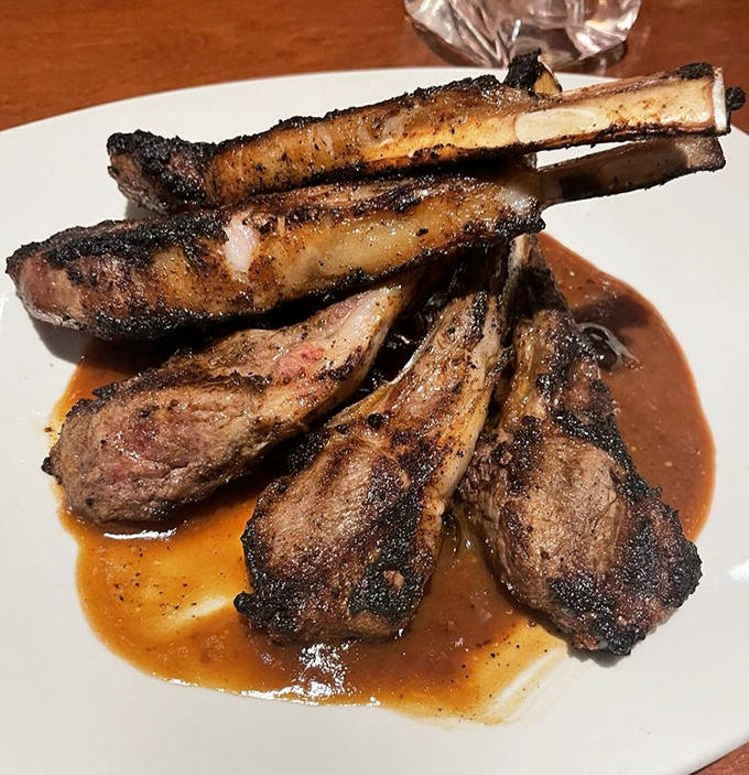 Lamb chops stacked like meaty Jenga, glistening with their savory sauce. Primal satisfaction meets culinary finesse on a single plate.