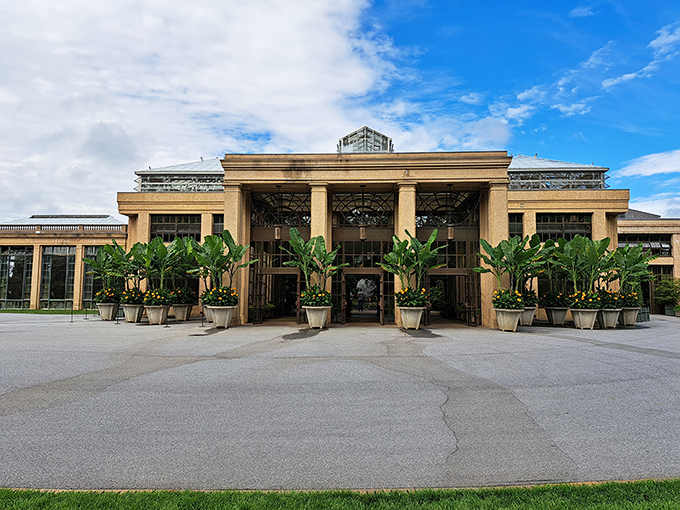The Conservatory entrance stands ready to transport visitors from Pennsylvania to paradise, flanked by banana plants that clearly didn't get the memo about local climate zones.