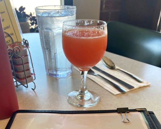 A mimosa in a wine glass sits ready to transform an ordinary morning into a celebration&mdash;breakfast's most elegant companion.