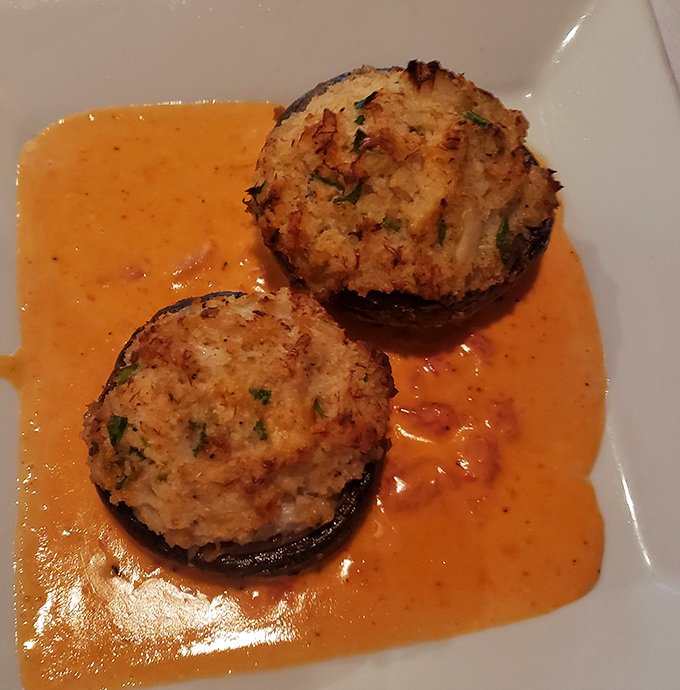 Stuffed mushrooms arrive like little edible treasure chests, each bite revealing layers of crab and seafood goodness within.