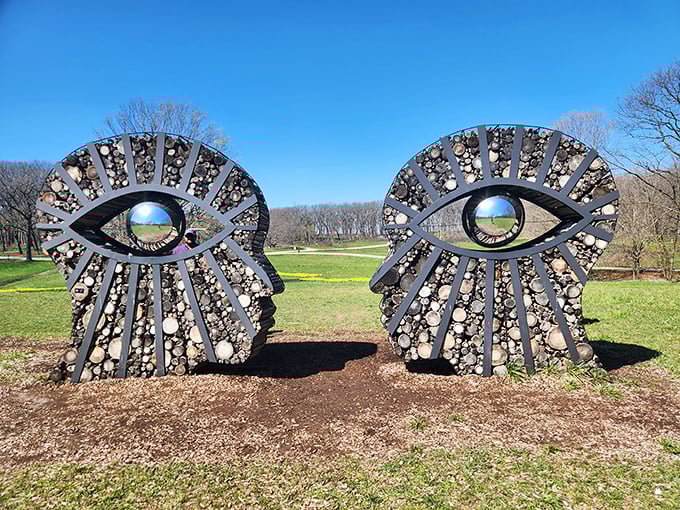 Two faces locked in eternal conversation, their eyes reflecting the landscape they observe&mdash;nature watching us watching nature in infinite recursion.