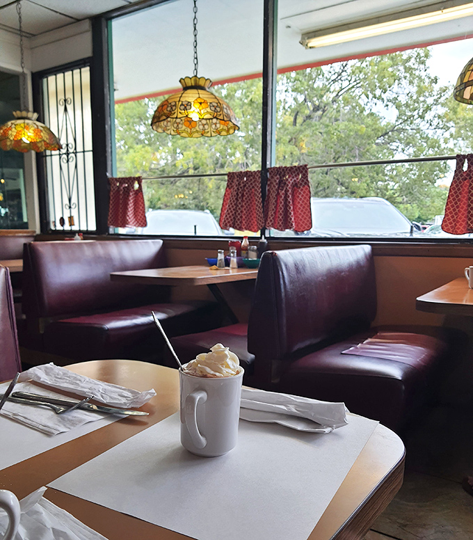 A white mug topped with whipped cream sits waiting, promising the kind of simple pleasure that fancy coffee shops have spent millions trying to replicate.