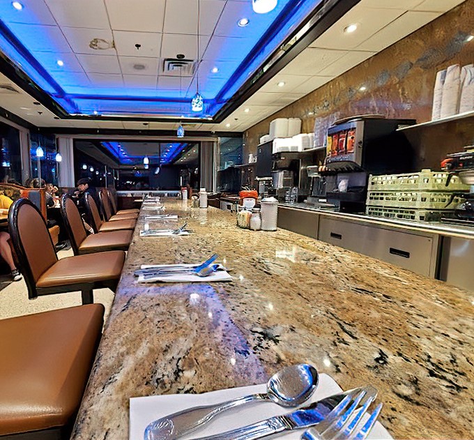 The counter stretches into infinity, its polished granite surface ready for early risers, late-night philosophers, and everyone in between.