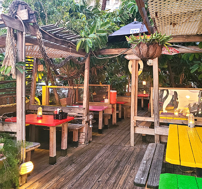 The outdoor seating area feels like a treehouse for grown-ups, where picnic tables and tropical plants create the perfect setting for serious burger business.