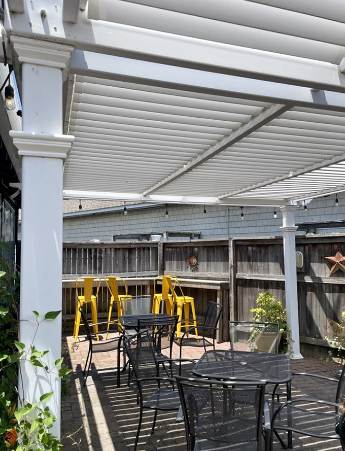 The outdoor patio&mdash;where vitamin D meets vitamin Sea. Those yellow bar stools practically shout "stay awhile" against the crisp white pergola.