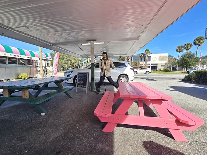 Outdoor picnic tables painted in signature pink offer al fresco dining with a side of Florida sunshine and people-watching.
