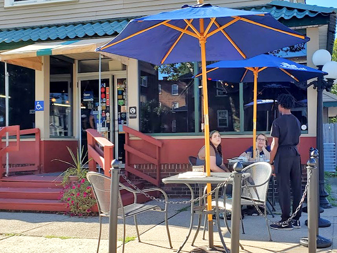 Outdoor seating under bright blue umbrellas offers a perfect spot for people-watching while savoring Southern specialties.