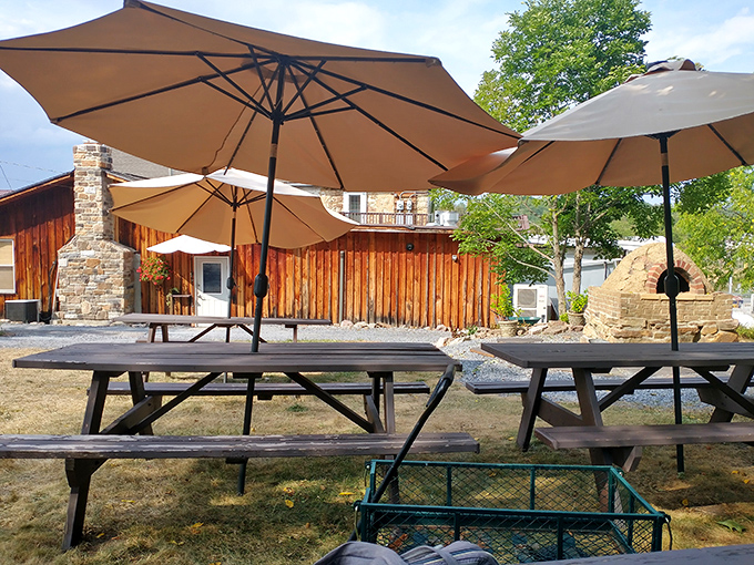 Picnic tables under umbrellas create an outdoor oasis where summer meals taste even better with a side of sunshine and fresh air.