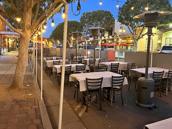 As evening falls, the outdoor dining area transforms into a twinkling oasis where ocean breezes carry conversations and the scent of grilled seafood.