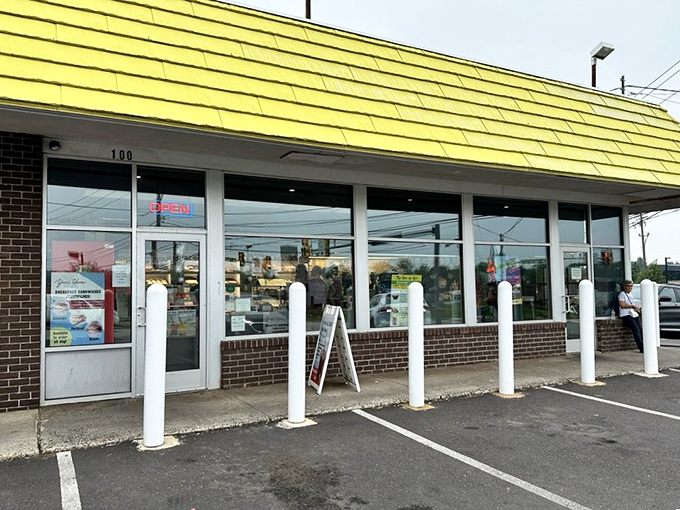 The storefront's white bollards stand guard like sentinels protecting the precious cargo inside. The "OPEN" sign &ndash; two syllables of pure joy.