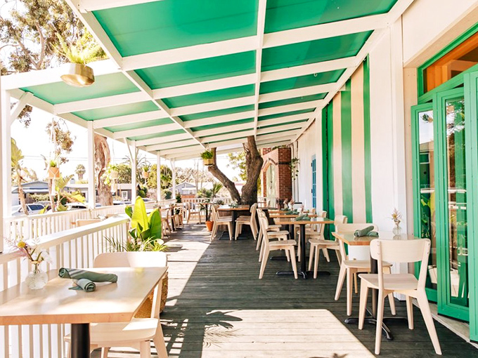 The outdoor patio, with its green-striped awning and natural wood tables, makes even Tuesday morning feel like you're on vacation somewhere that requires a passport.