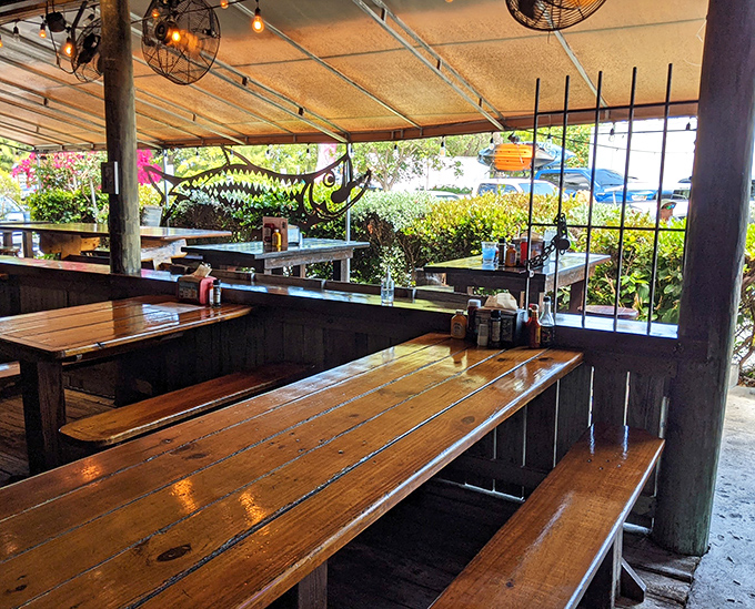 Wooden picnic tables under a simple canopy&mdash;where conversations flow as easily as the beer and seafood arrives with zero fanfare but maximum flavor.