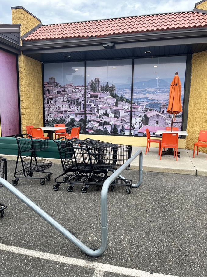 Outdoor seating with a view of Italian hillsides on window murals. The bright orange chairs practically shout "Sit down and enjoy life for a minute!"