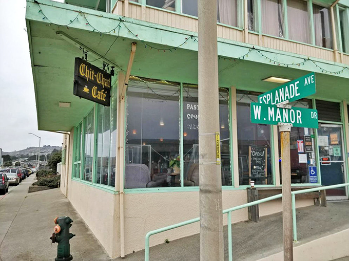 At dusk, the cafe's exterior takes on a magical quality—turquoise lights glowing against the pastel horizon like a beacon for hungry souls.