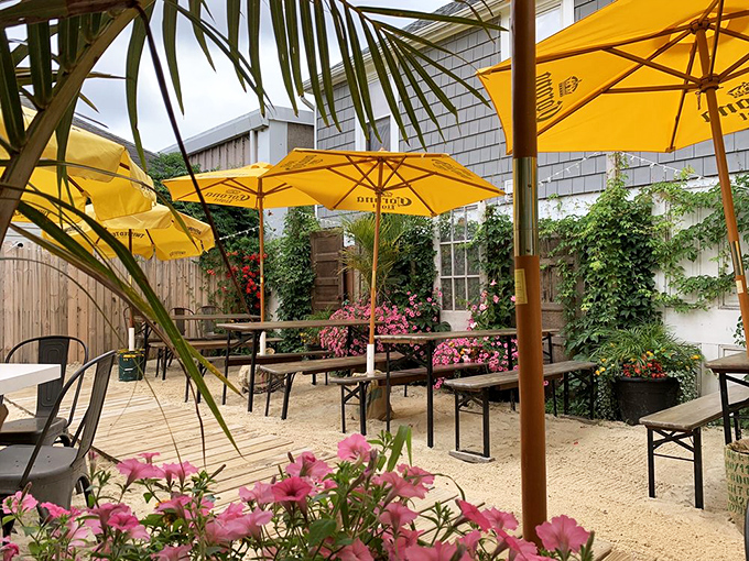 Beach vibes meet sports bar functionality with surfing on the big screen and a "No Bad Vibes" sign that serves as both decoration and house rule.