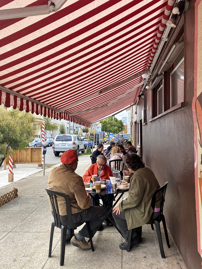 Sidewalk dining under a classic red and white striped awning&mdash;where Mission District conversations blend with the clinking of coffee cups and forks.