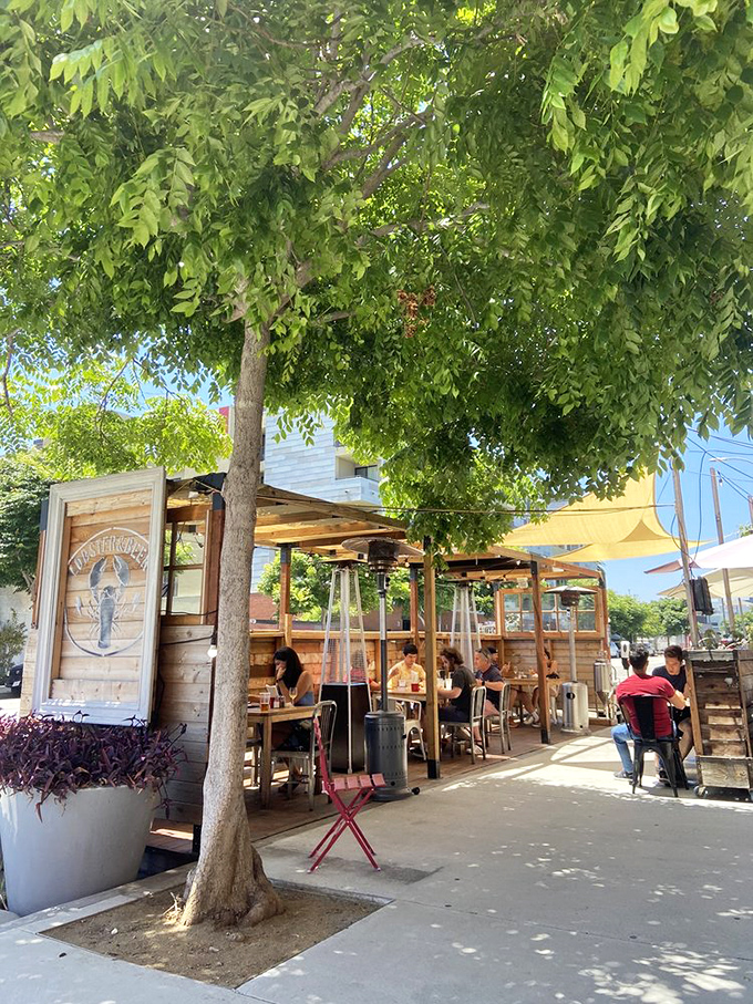 Outdoor seating under leafy shade &ndash; nature's dining room for enjoying ocean treasures in urban LA.
