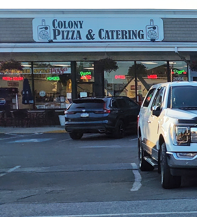 The neon signs glow like a lighthouse guiding hungry travelers to pizza salvation on West 26th Street.