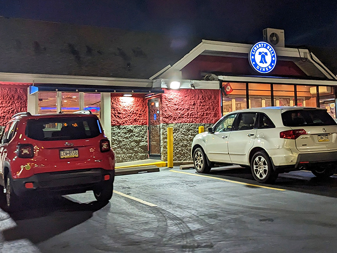 Even at night, the Liberty Bell Diner's glow serves as a beacon for hungry souls seeking comfort food salvation. 