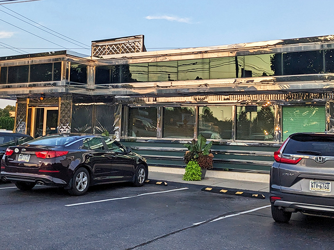 The parking lot at dusk, where cars gather like faithful pilgrims at a temple of comfort food worship.